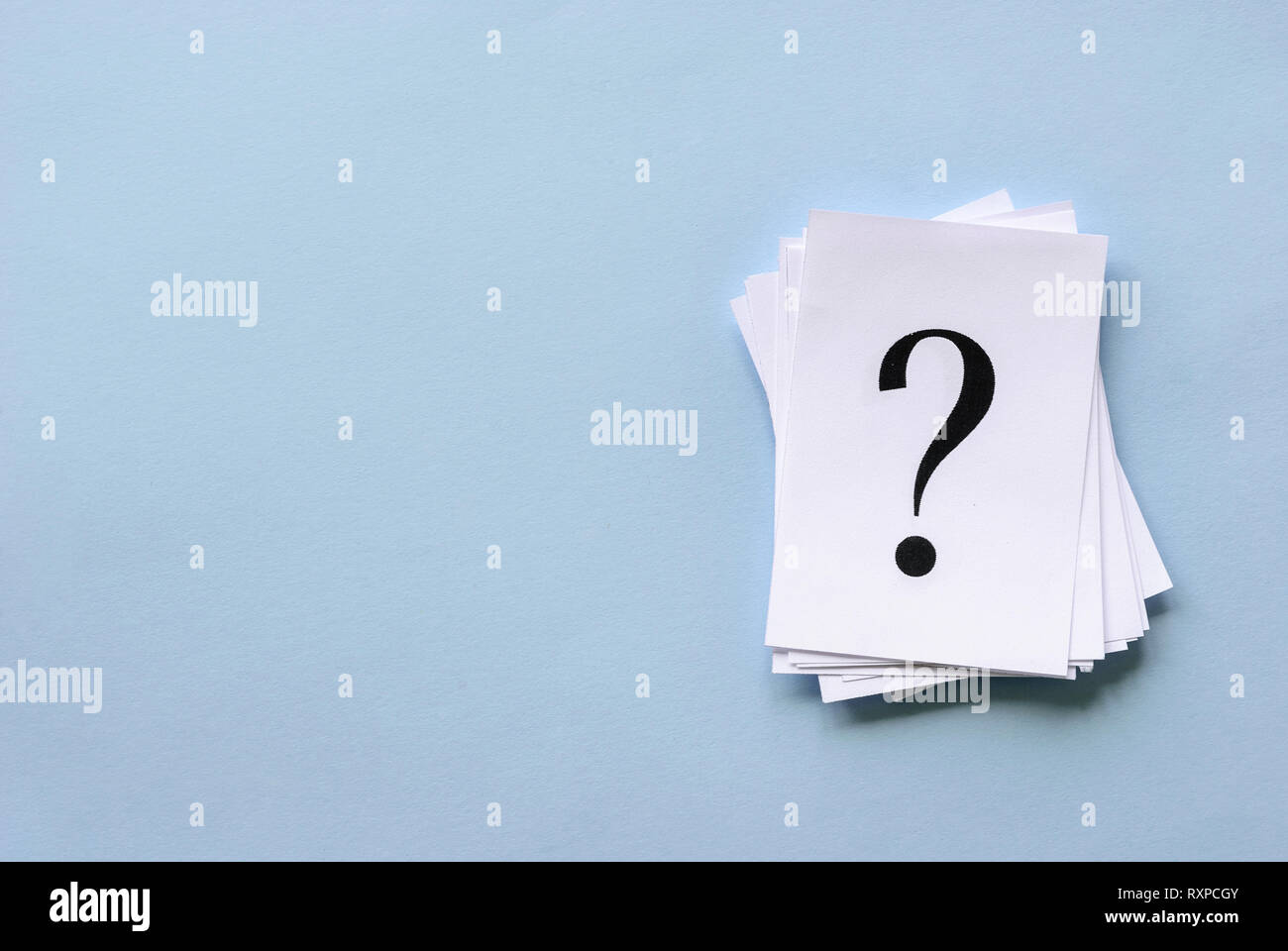 Pile of stacked question marks printed on sheets of white paper or ...