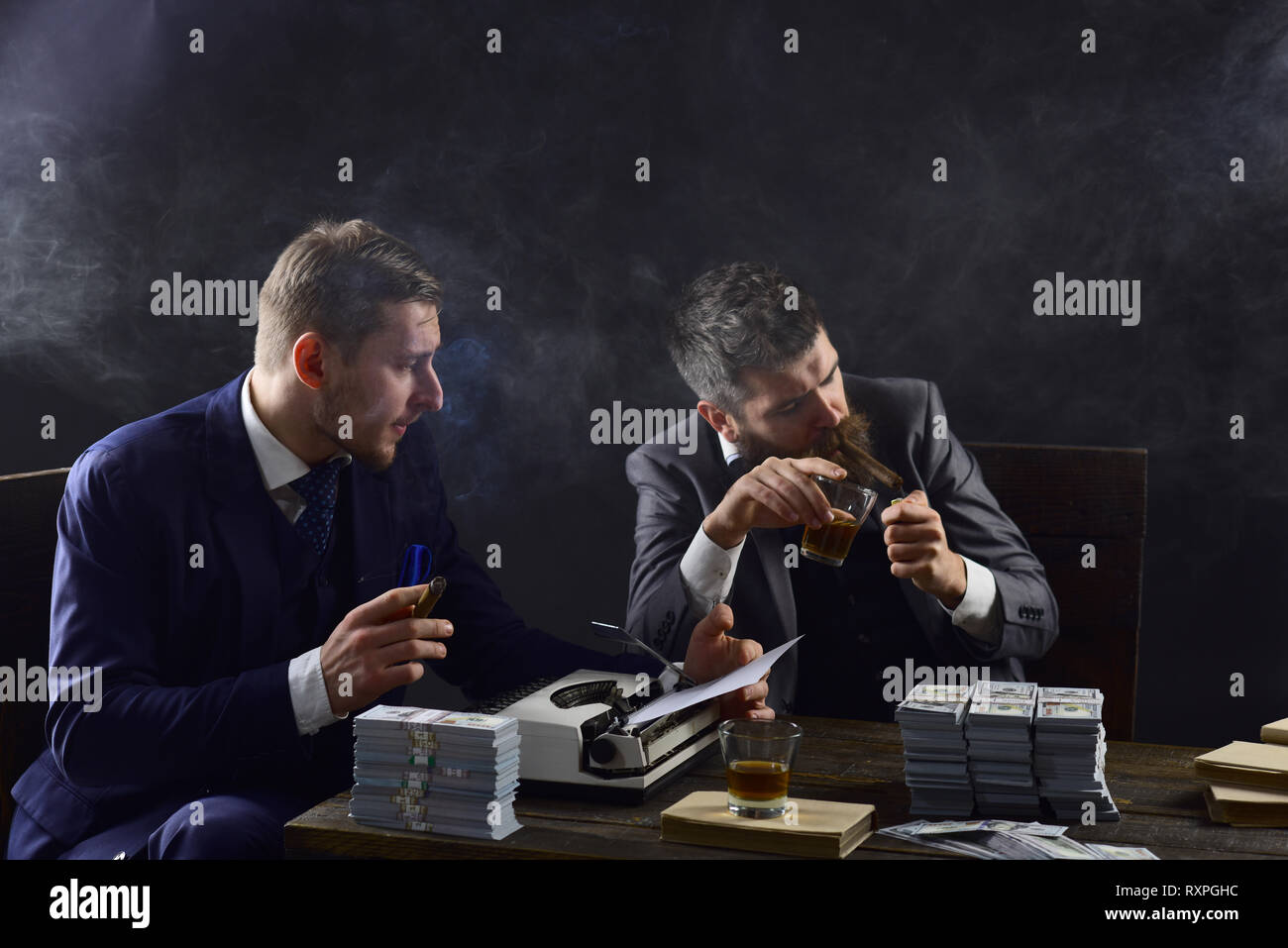 Men sitting at table with piles of money and typewriter. Illegal ...