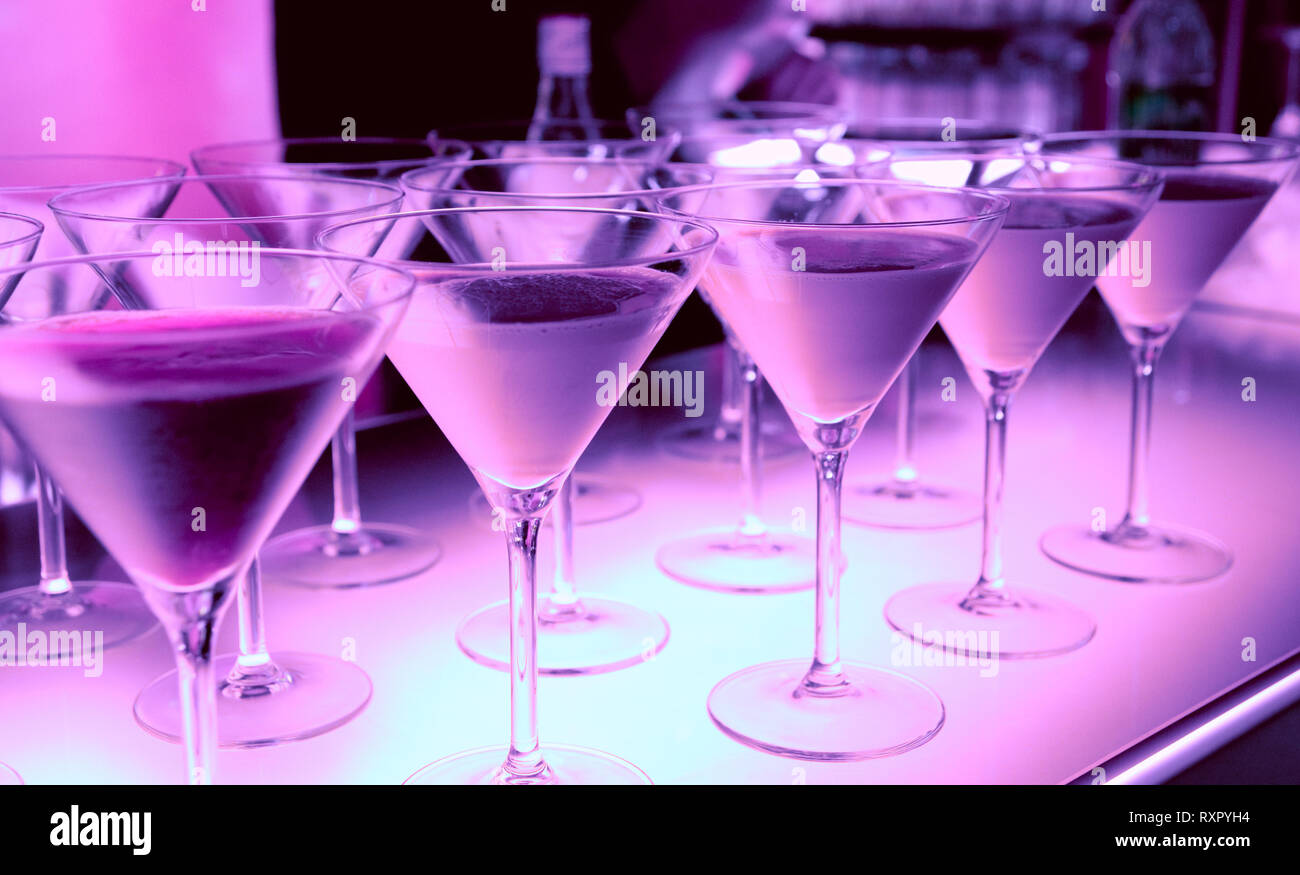 Welcome drink in a night club cocktails on illuminated bar counter ...