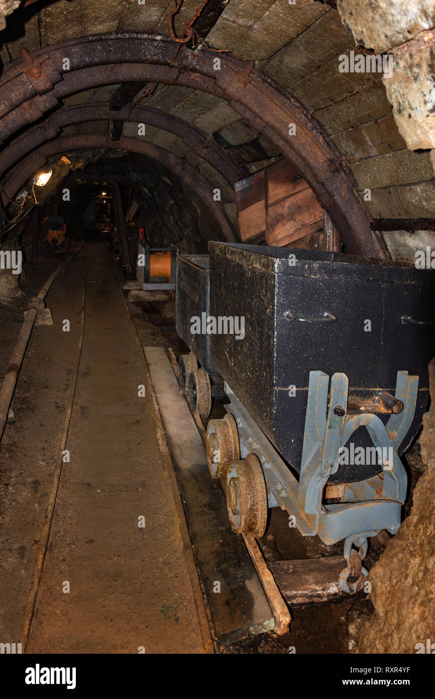 Old metal mine train with rusty wheels in mine tunnel with wooden ...