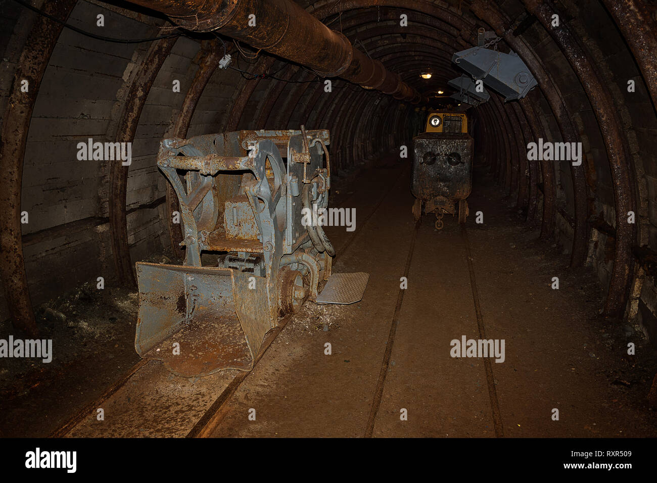 Old and rusty mine machine and train with wagons in mine shaft with ...