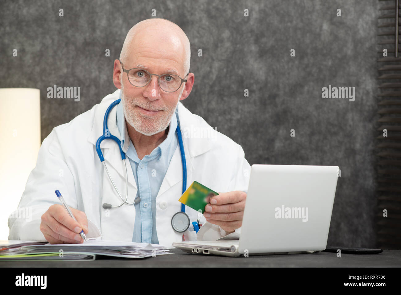 a senior bearded doctor with health insurance card Stock Photo - Alamy