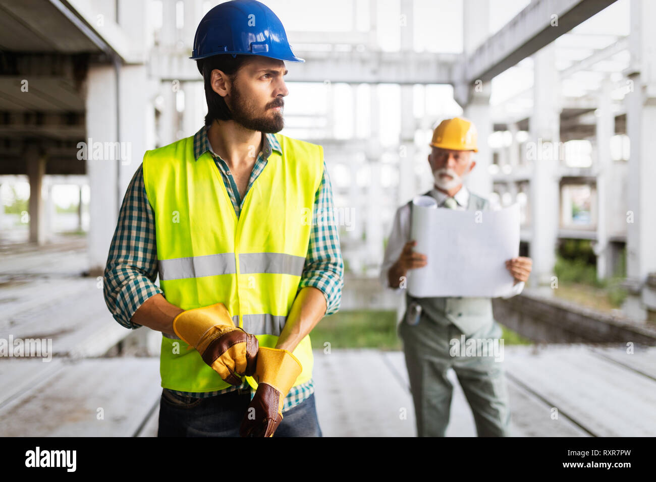 Engineer and construction site manager dealing with blueprints and ...