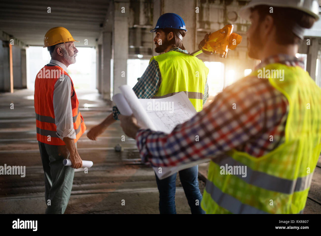 Engineer and construction site manager dealing with blueprints and ...