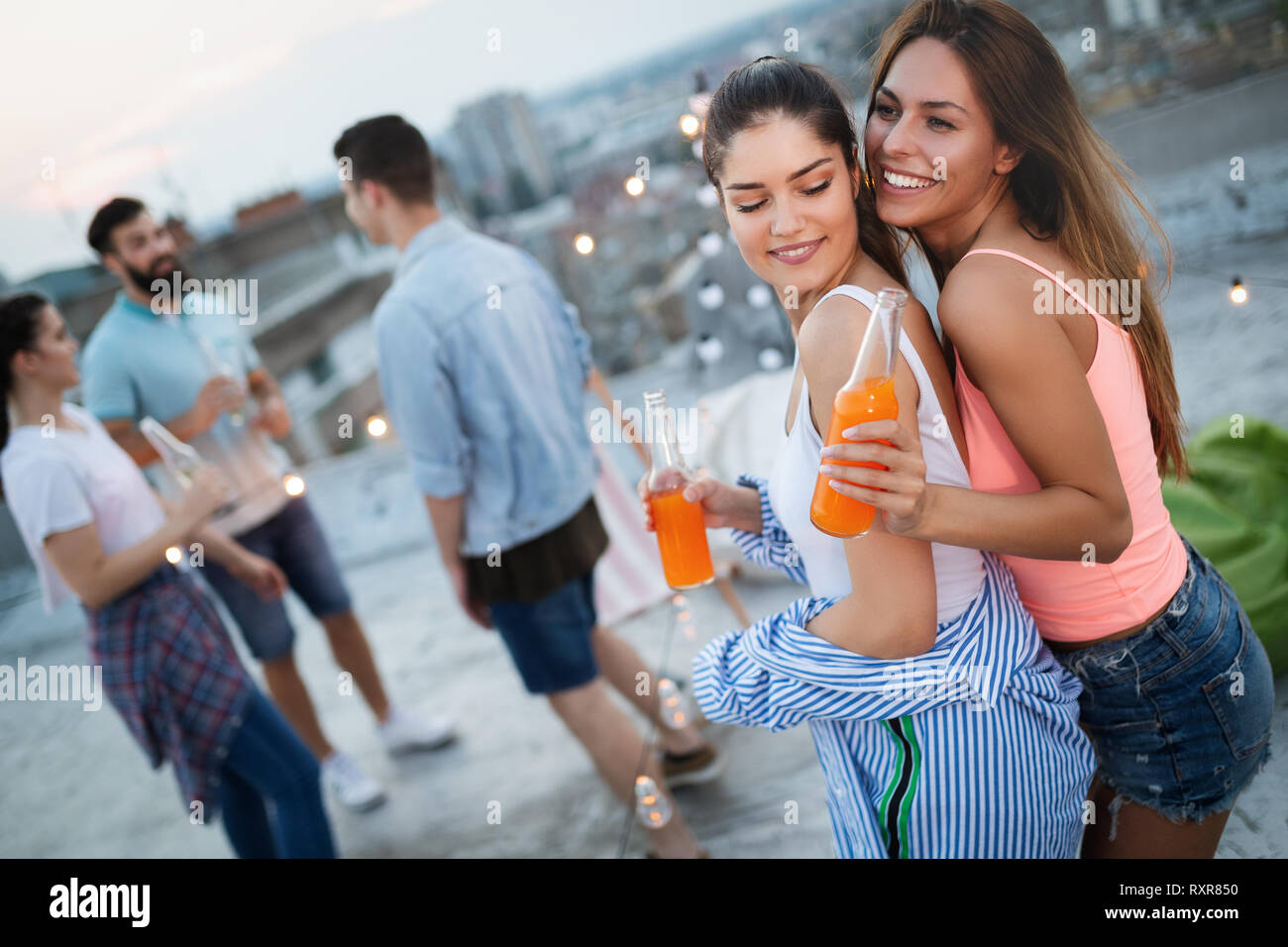 Group of happy young friends having party on rooftop Stock Photo - Alamy