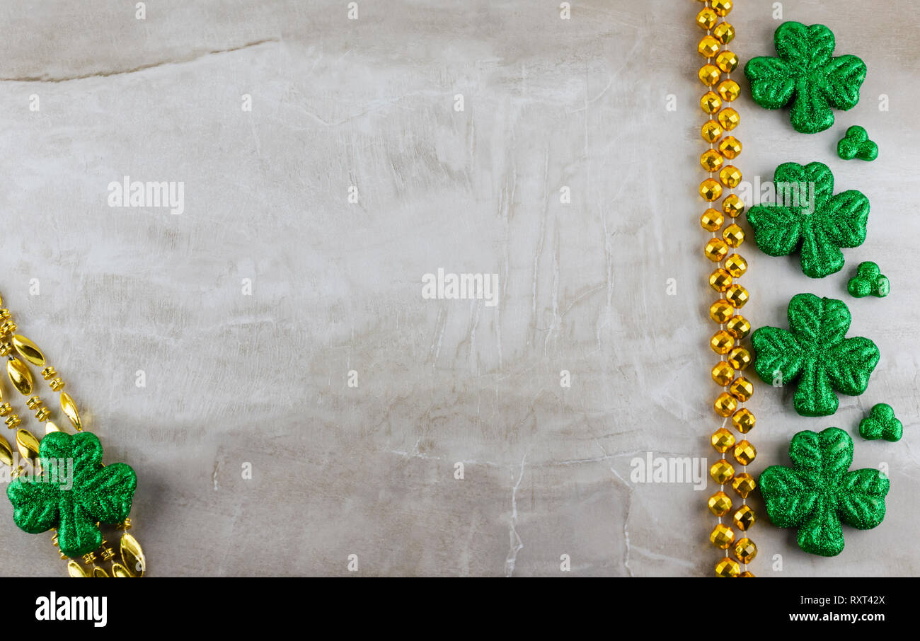 Overhead shot of a line of shamrocks and gold beads on right hand side ...