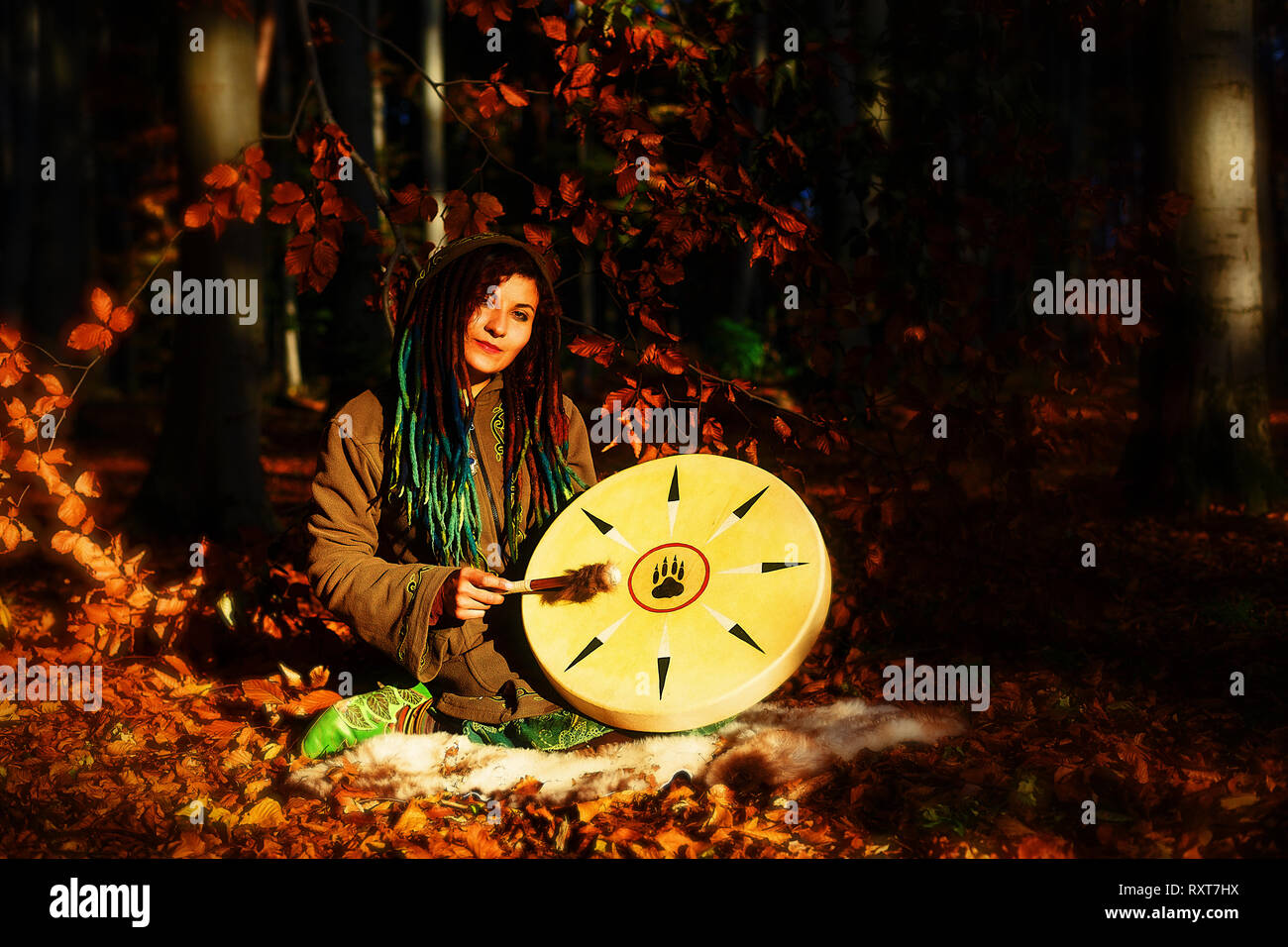 beautiful shamanic girl playing on shaman frame drum on background with ...
