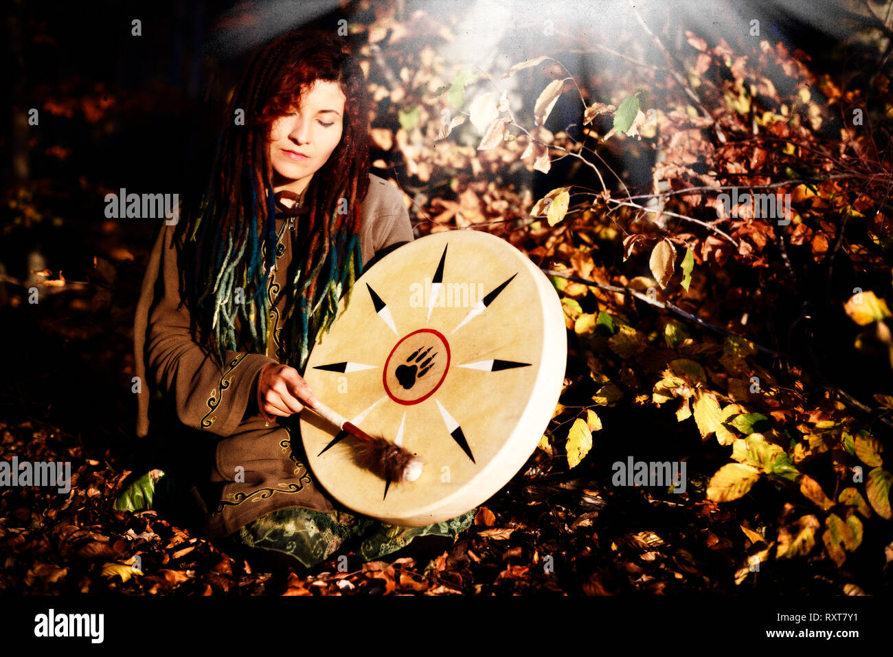 beautiful shamanic girl playing on shaman frame drum on background with ...