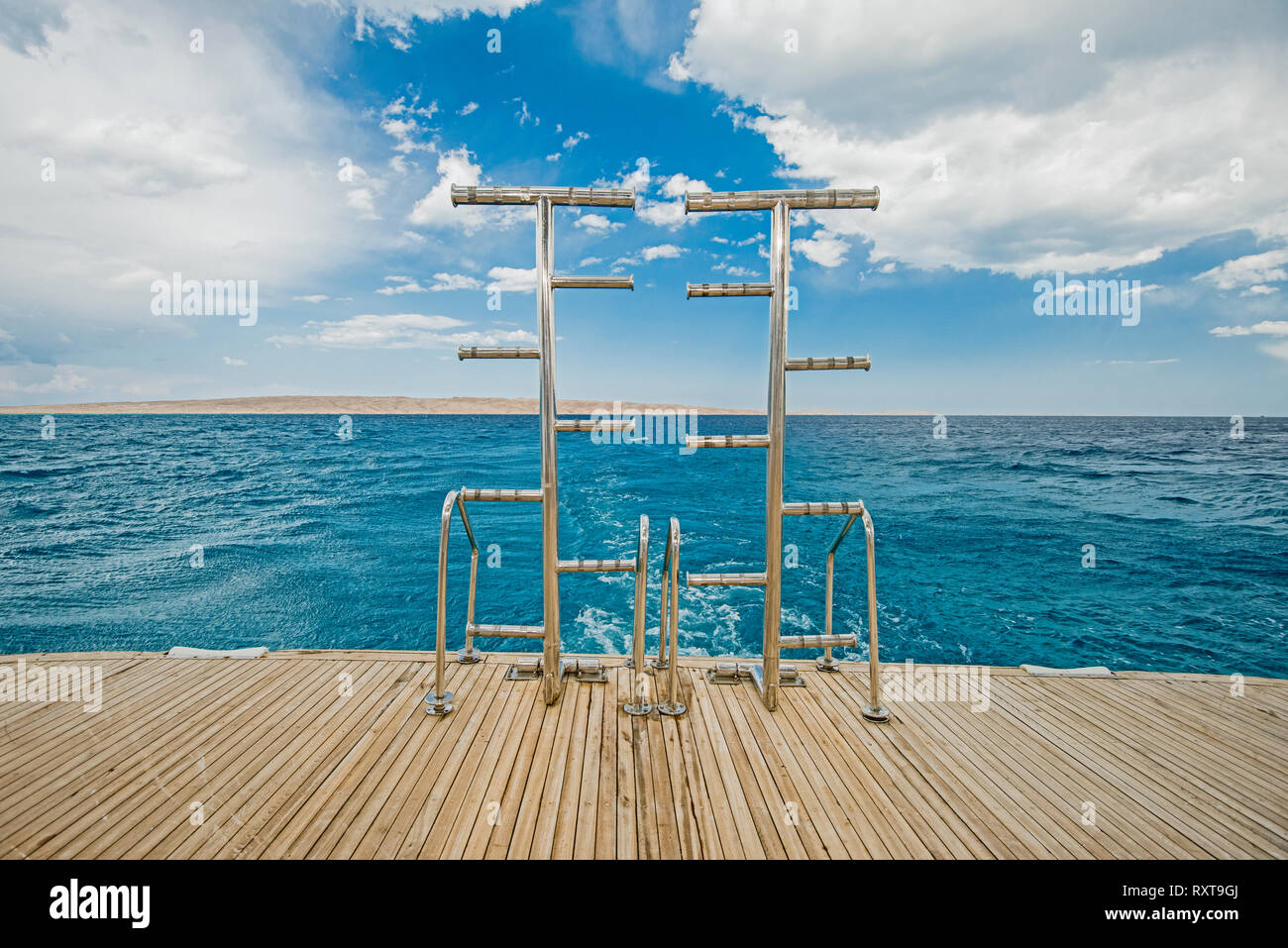 Metal steel ladders on back teak deck of a luxury motor yacht sailing ...