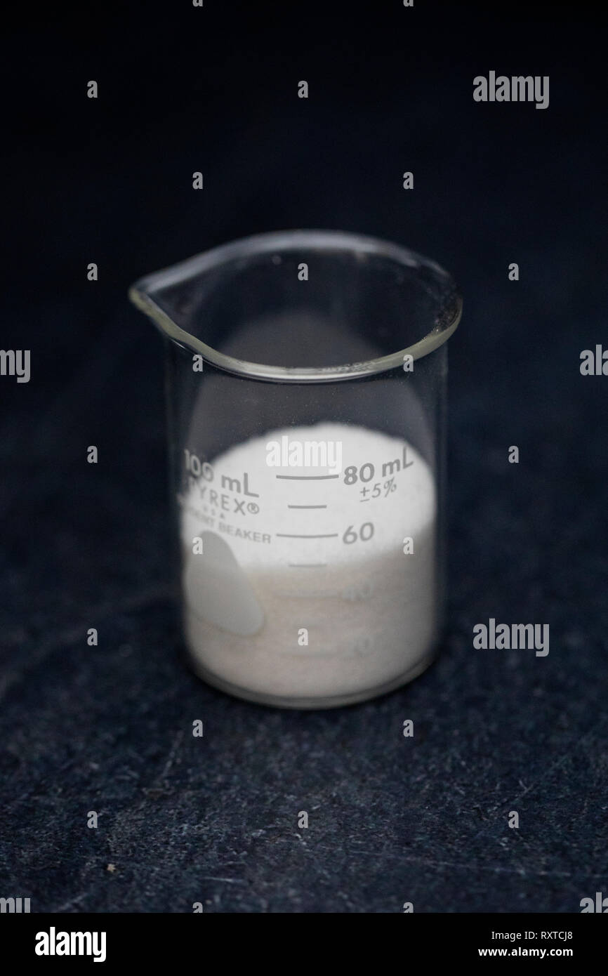 Sugar crystals in a beaker on a dark background Stock Photo - Alamy