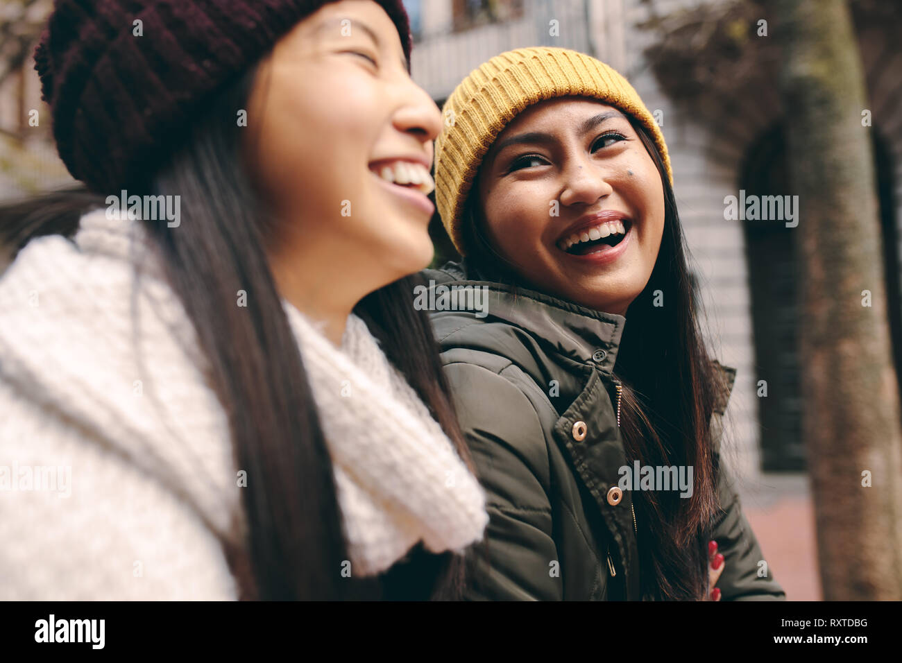 Side view of two asian women in winter clothes standing outdoors. Women ...