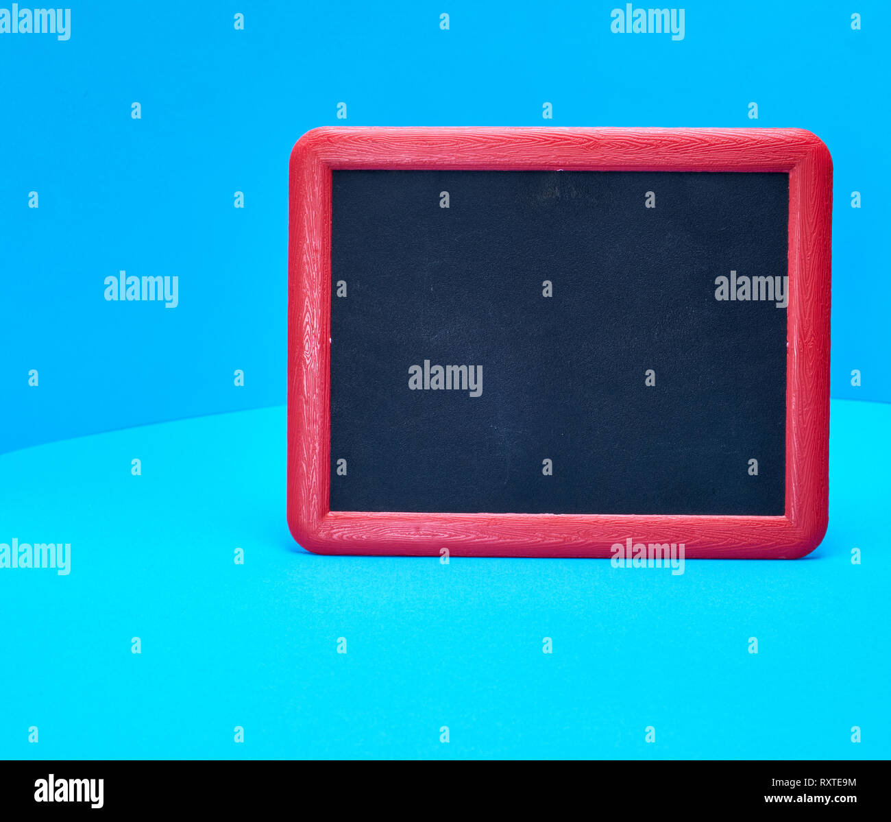 empty chalk board in red frame on blue background, copy space Stock ...