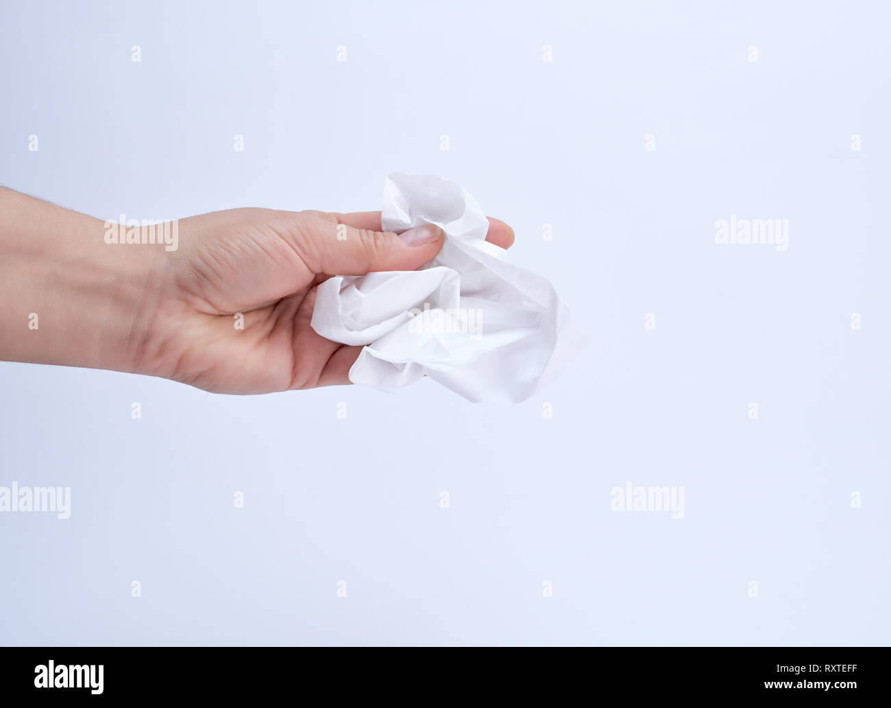 female hand holding a clean white paper napkin for face and body, white ...