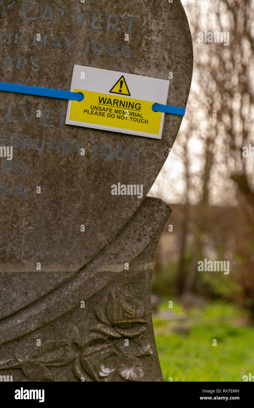 A sign warning an unsafe memorial fixed to a gravestone in Tottenham ...