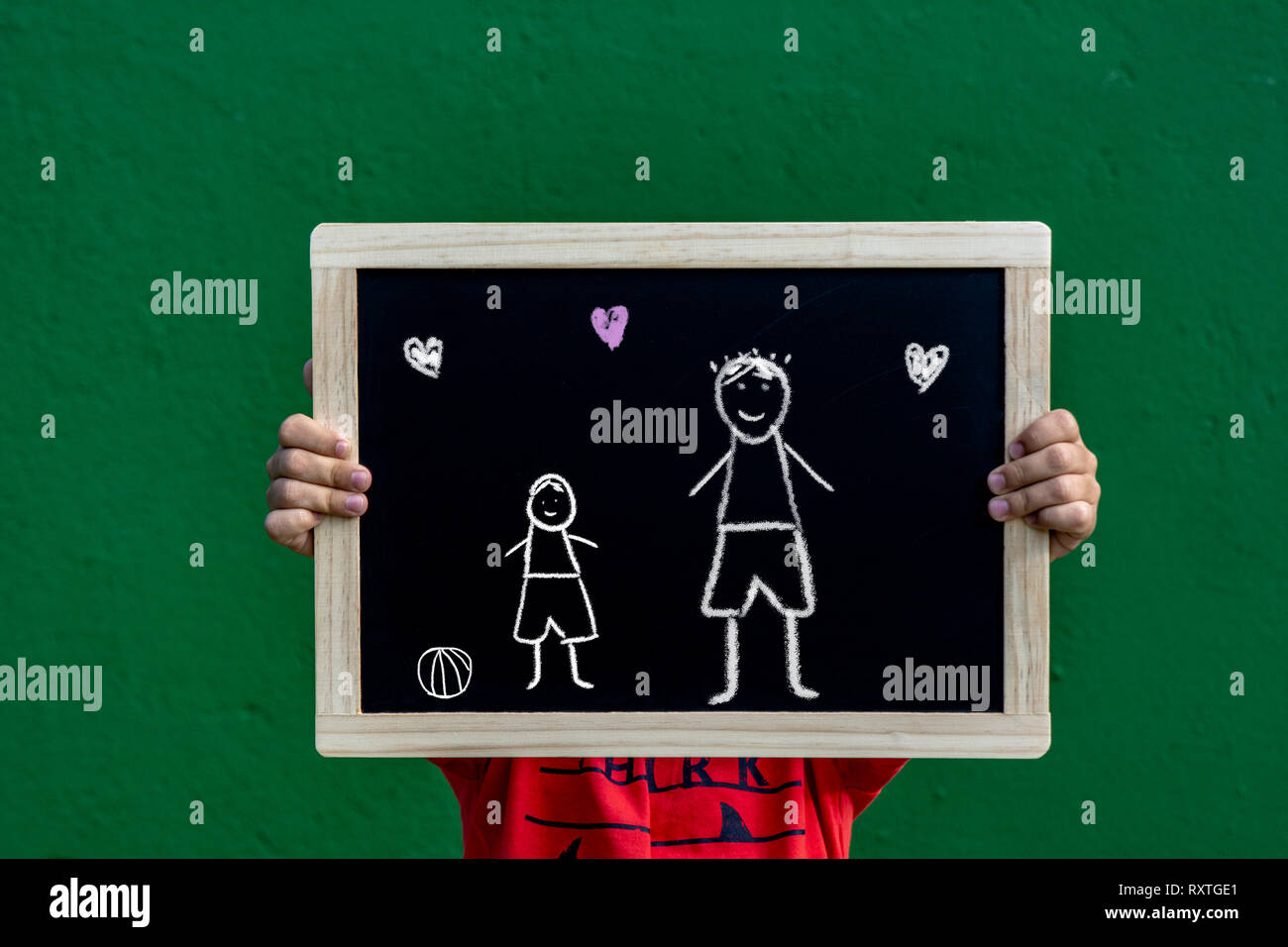 boy with chalkboard displaying Happy Father's Day drawing in chalk ...