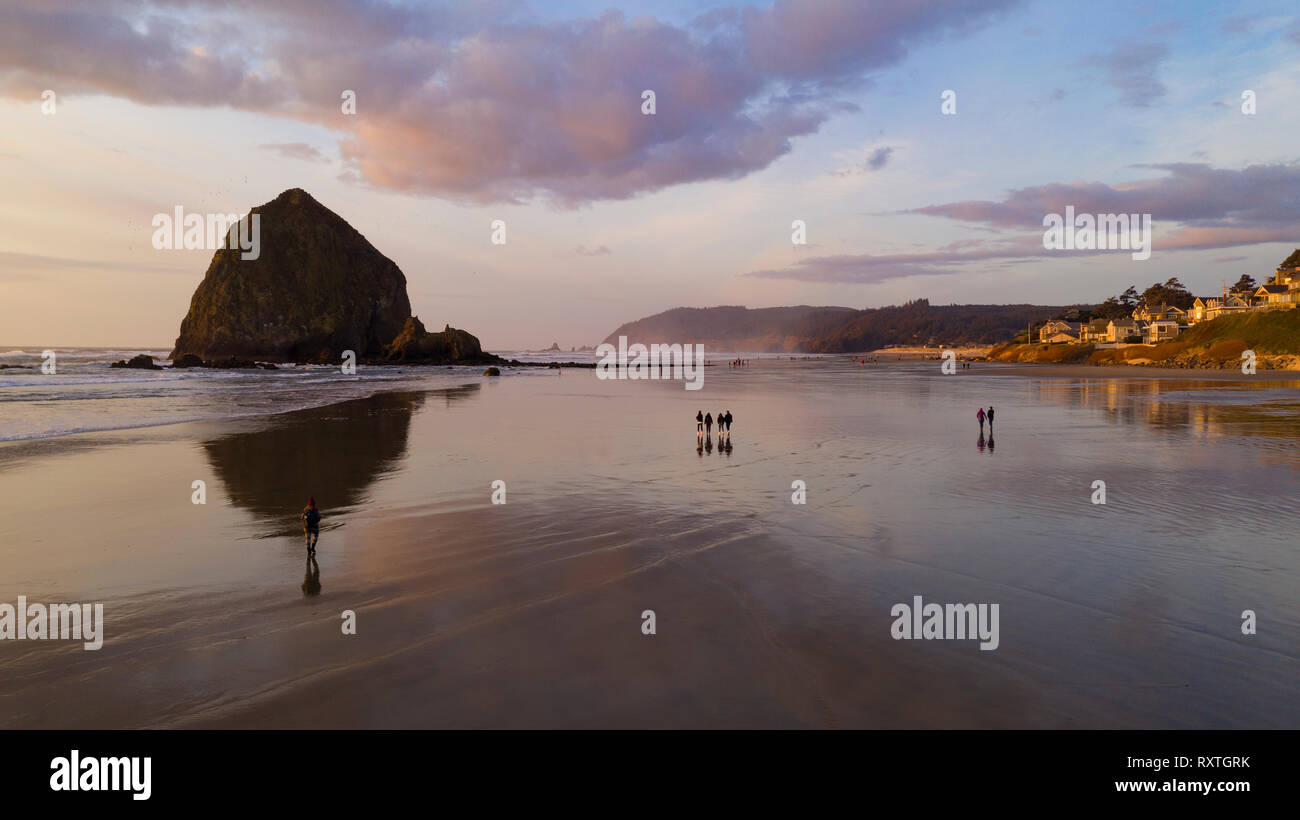 People walk on the beach reflection late afternoon at dusk in Cannon ...