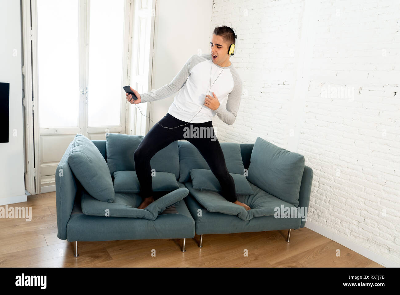 Portrait of young happy teenager male listening to music in headphones ...