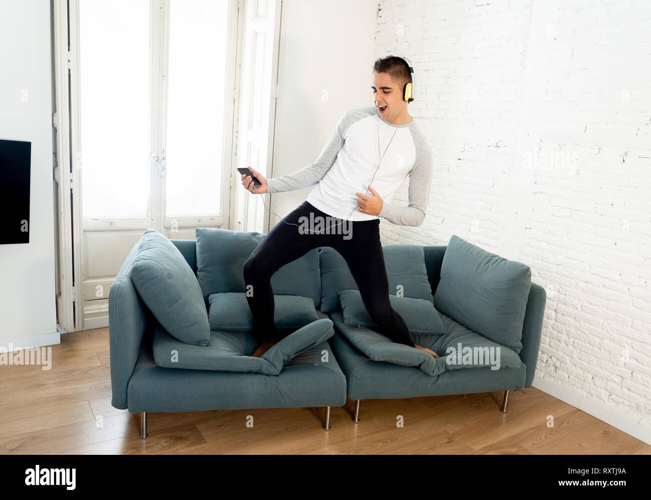 Portrait of young happy teenager male listening to music in headphones ...