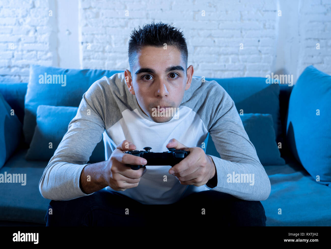 Portrait of young student man playing video games at night using ...