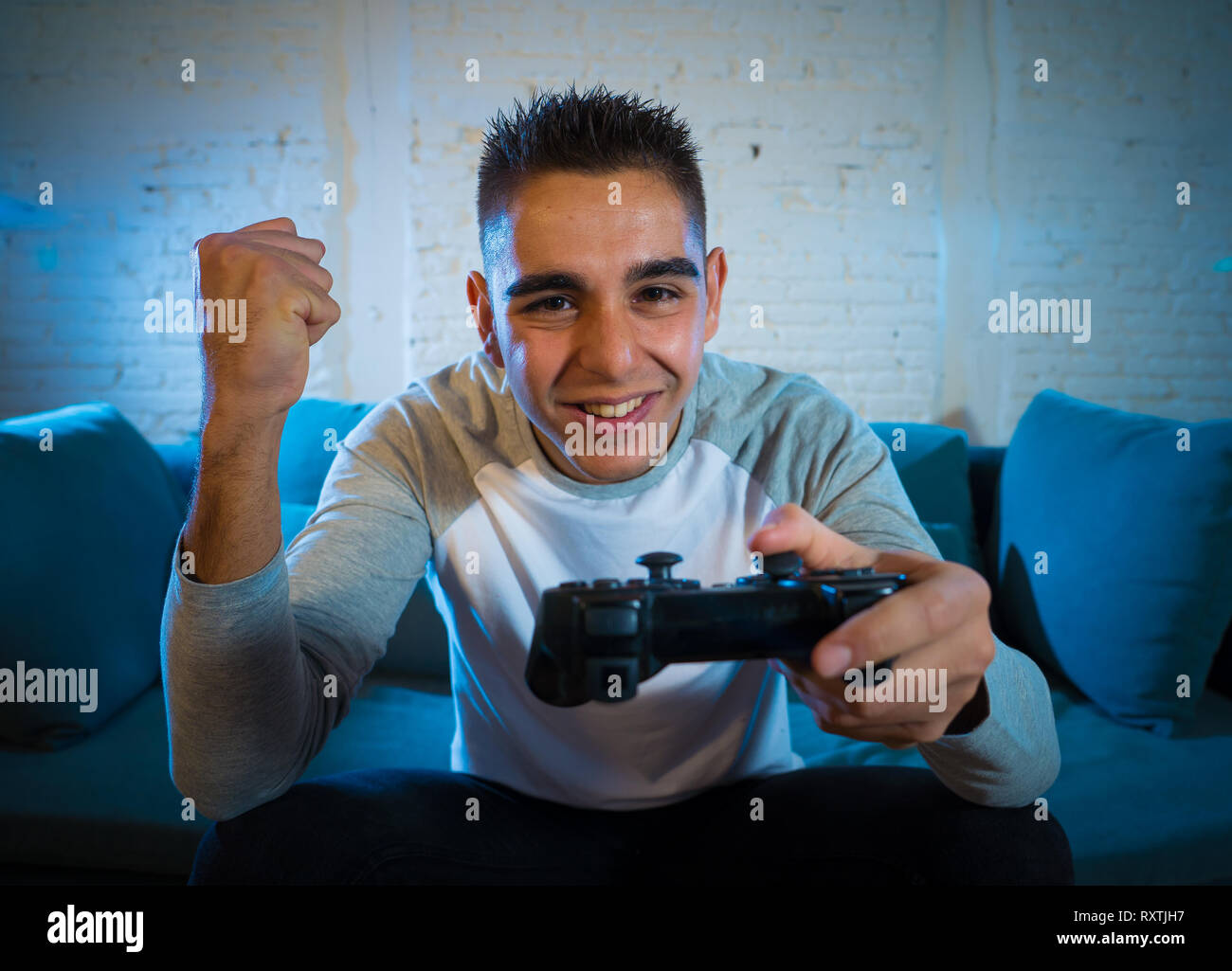 Portrait of young man having fun playing video games using wireless ...