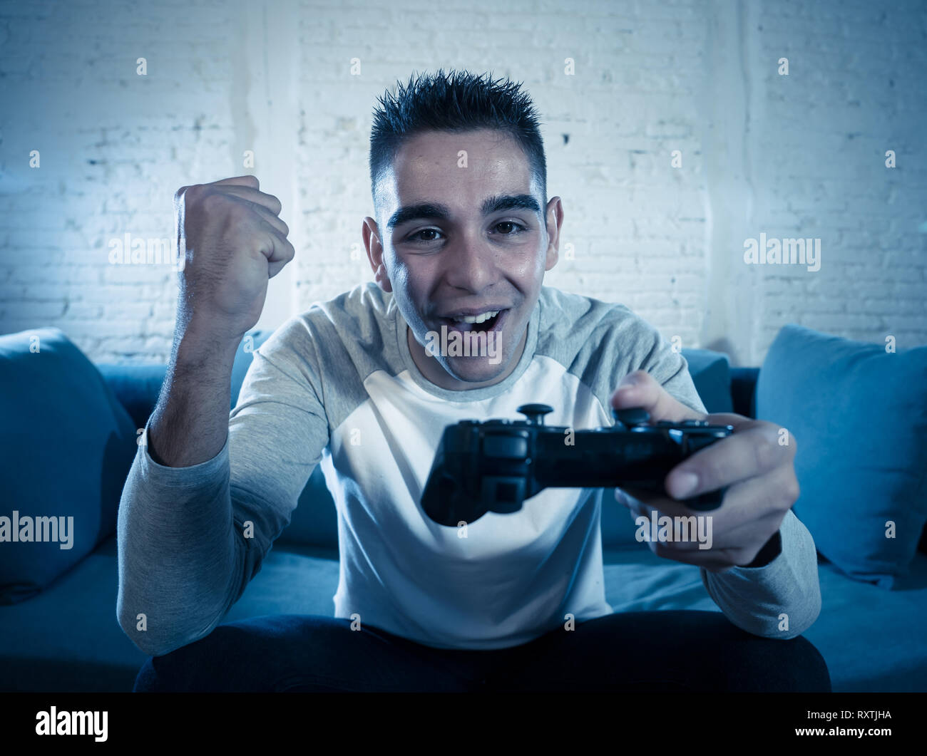Portrait of young man having fun playing video games using wireless ...