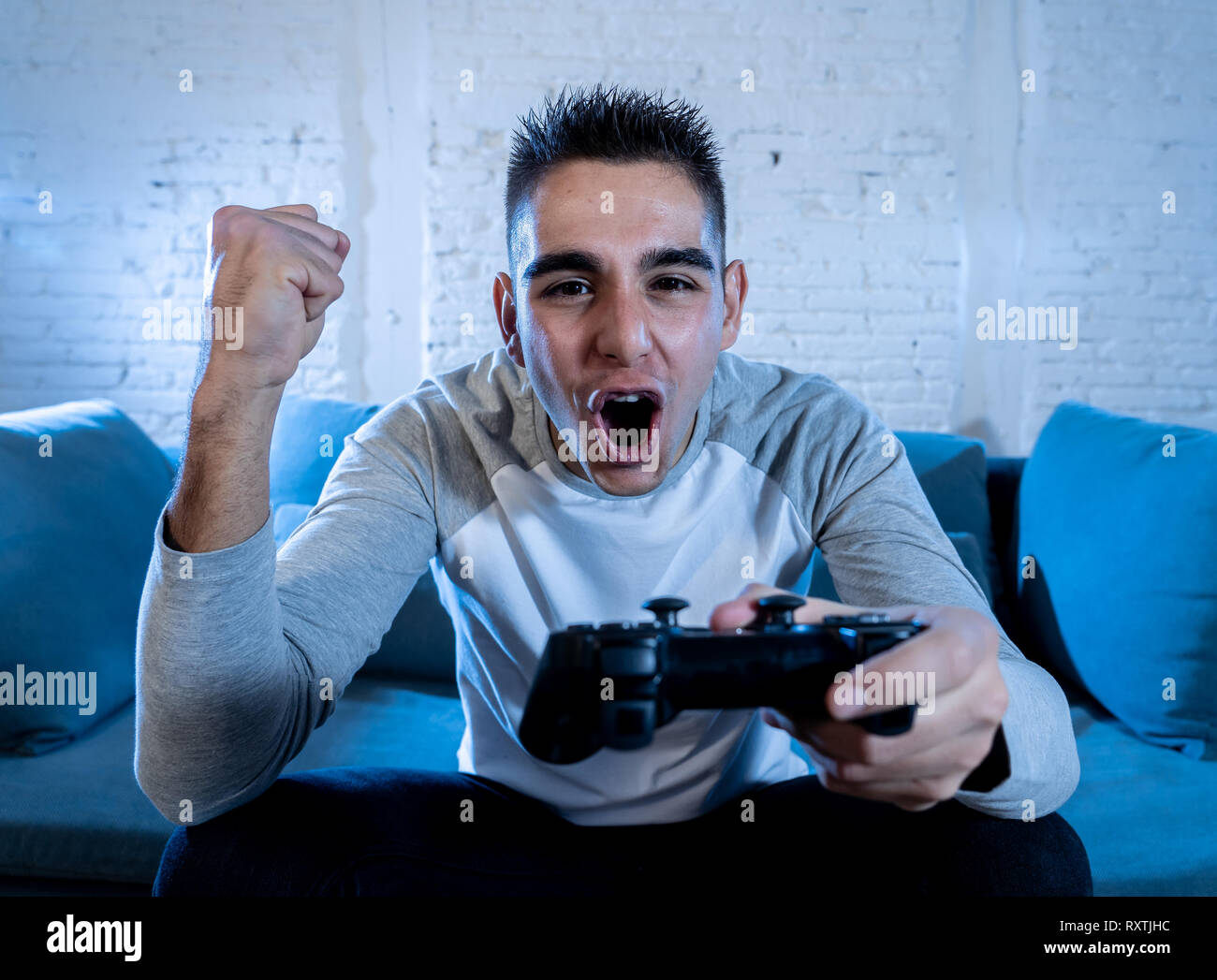 Portrait of young man having fun playing video games using wireless ...