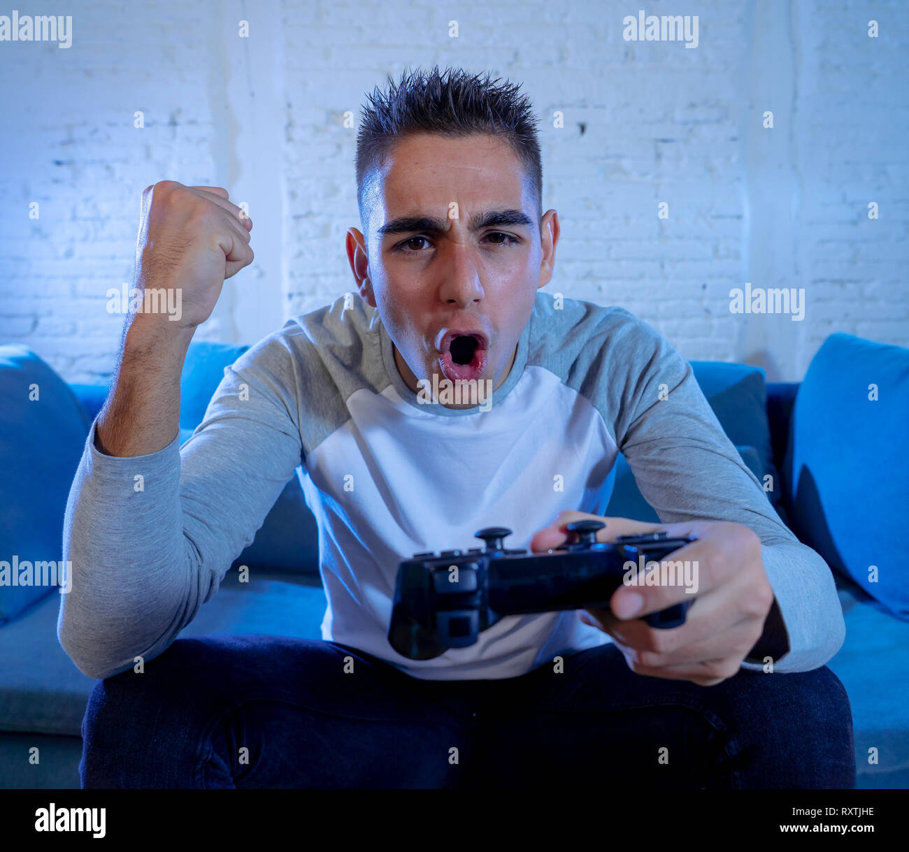 Portrait of young man having fun playing video games using wireless ...