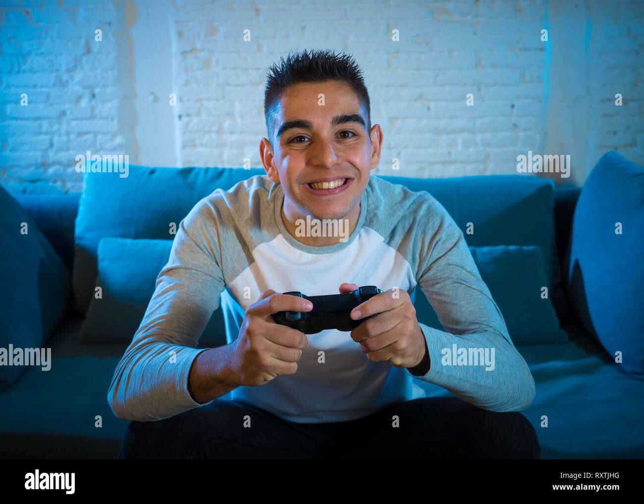 Portrait of young man having fun playing video games using wireless ...
