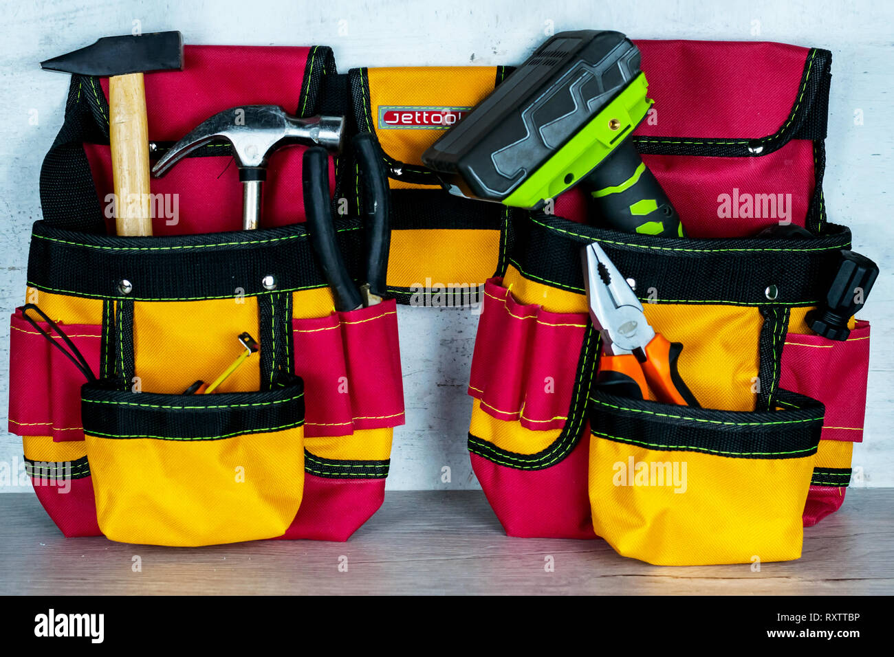 Full tool bag on a white concrete wall background. The concept of ...