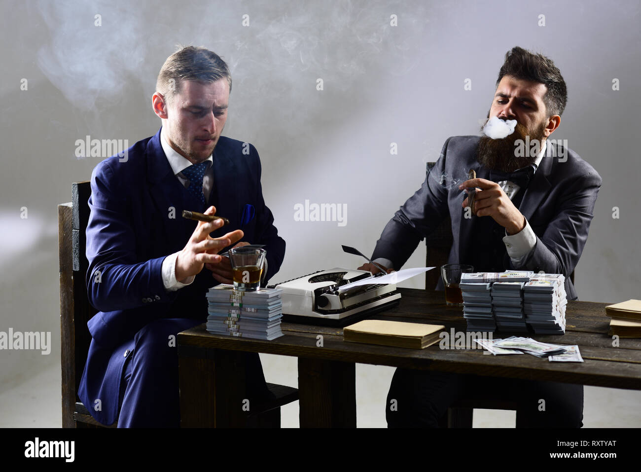 Men sitting at table with piles of money and typewriter. Company ...