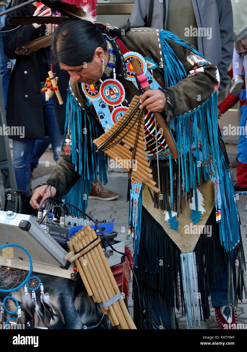 Female, indigenous,South American, street performer playing pan flute ...