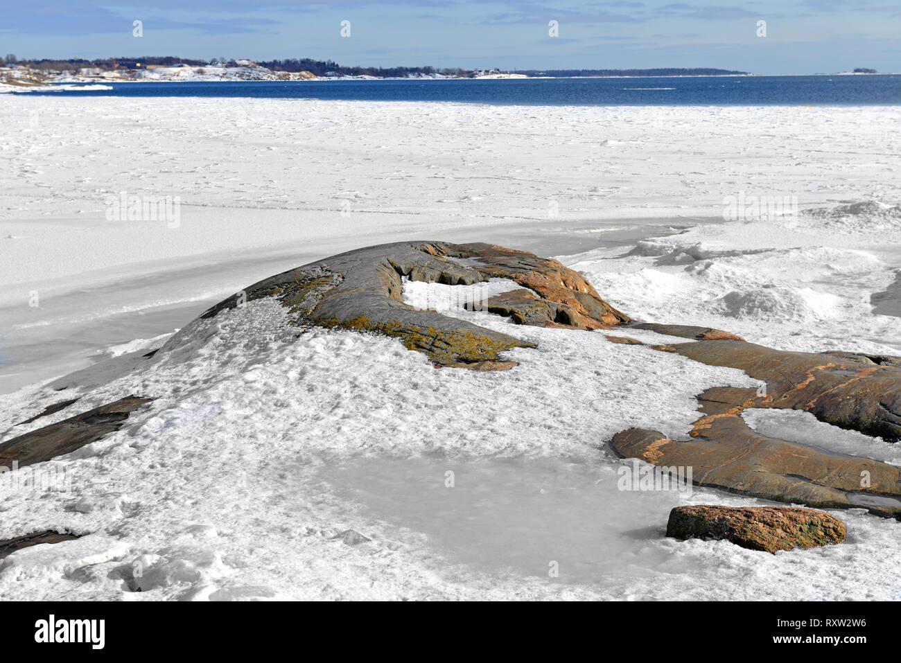 Rocky coast of snow-covered island of Helsinki archipelago, Finland ...