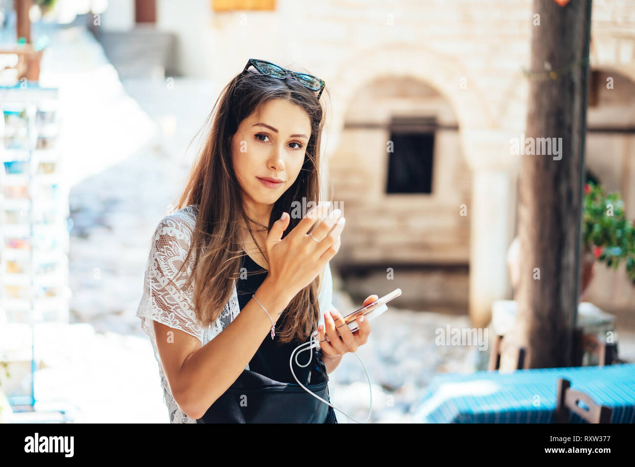 A girl is holding a phone and posing on the camera Stock Photo - Alamy