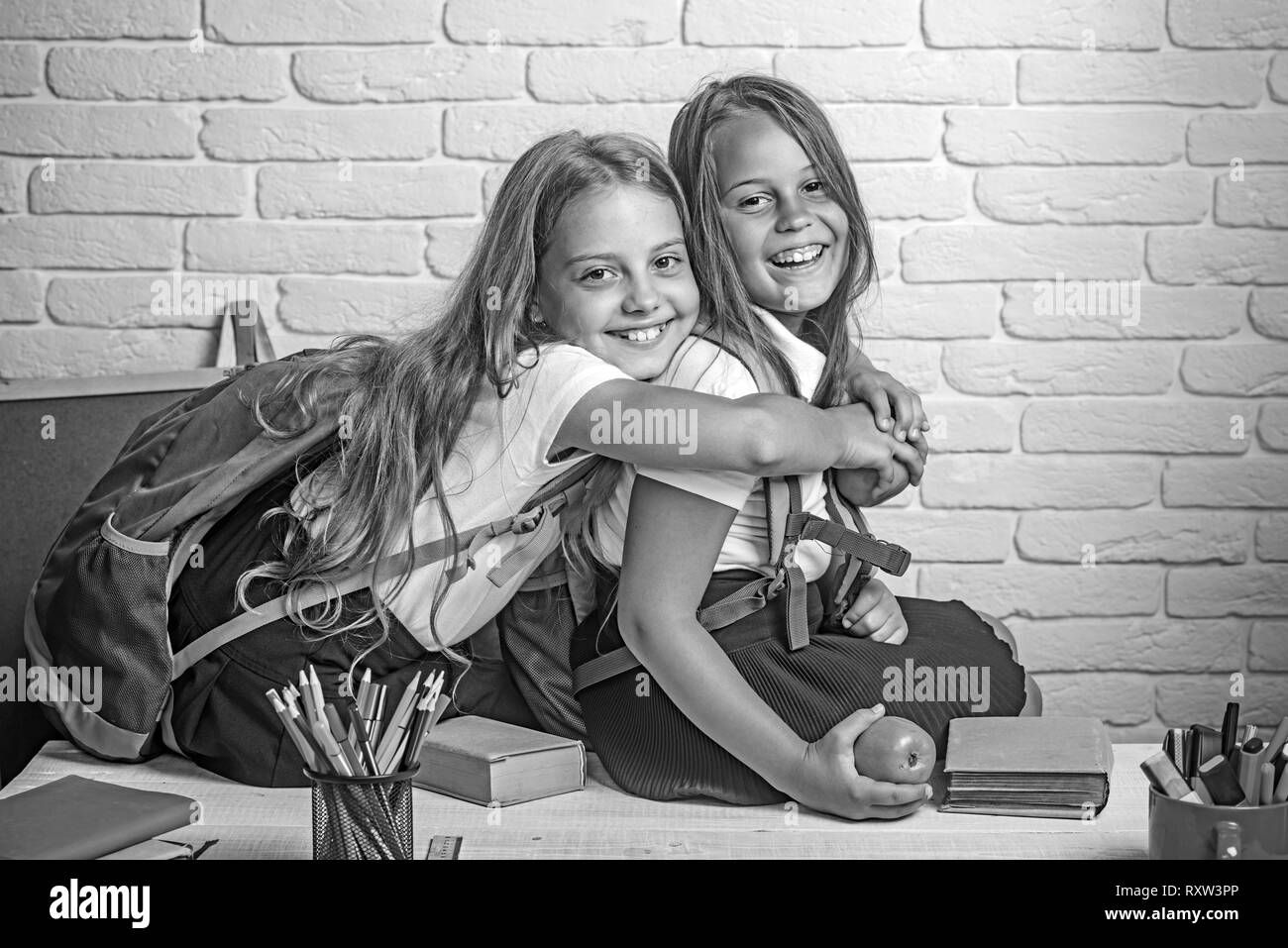 Little girls eat apple at lunch break. little girls eambrace at school ...