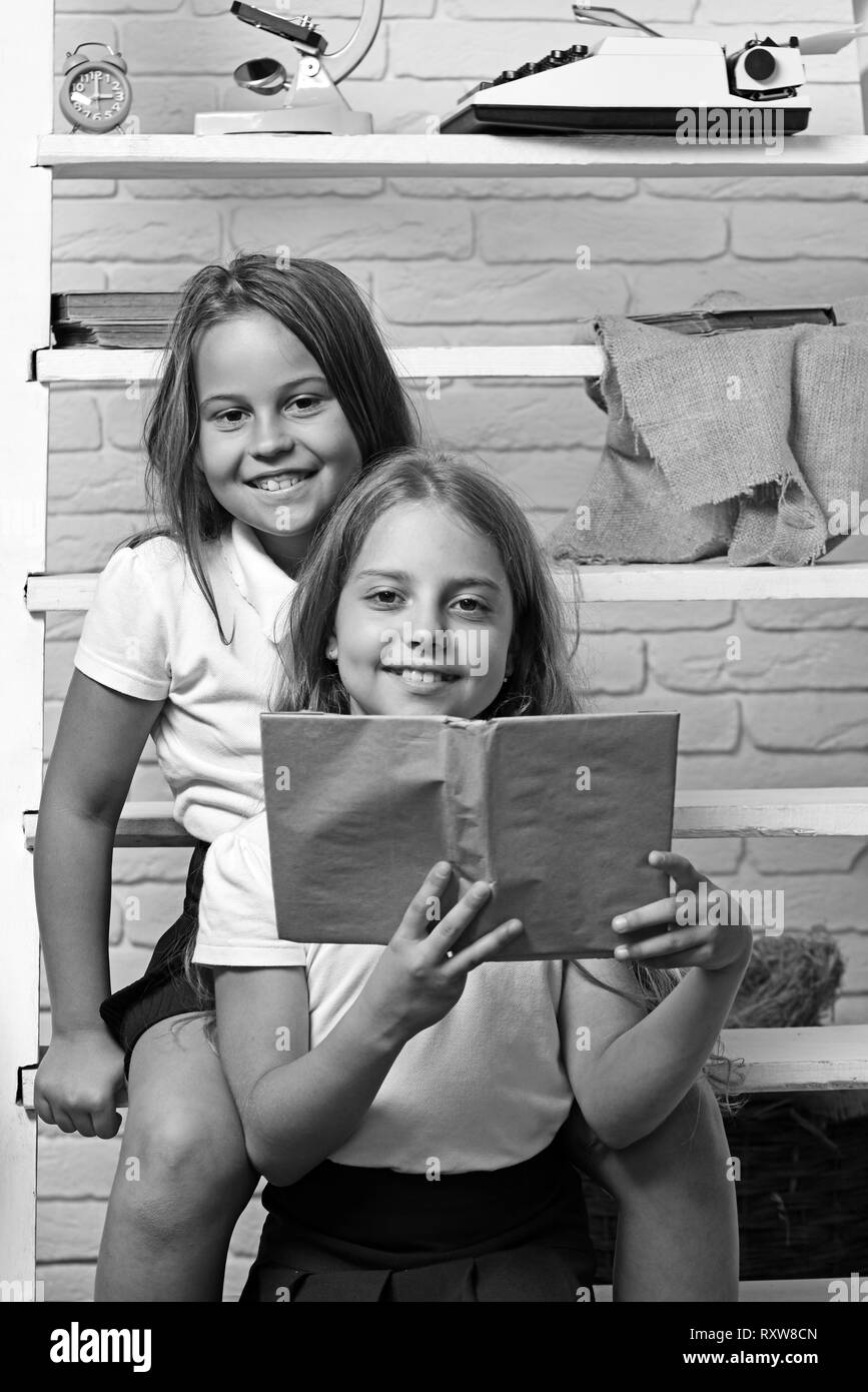 Little girls children reading a book in the library Stock Photo - Alamy