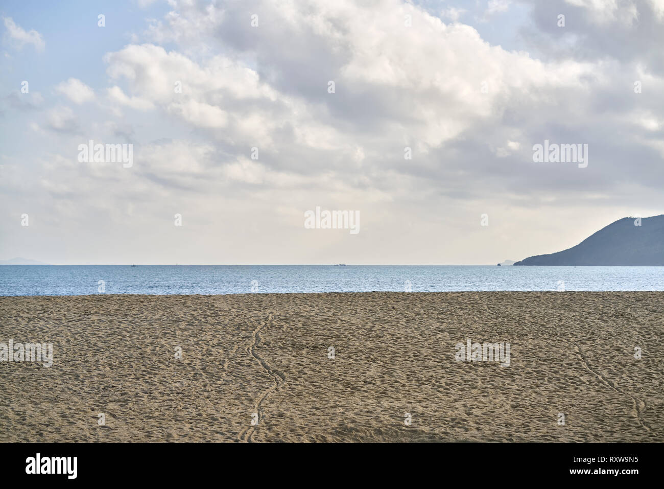 Peaceful sand beach on the background of the sea with few boats and ...