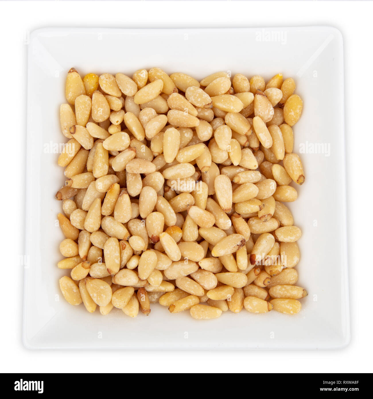 Fresh Pine Nuts in a bowl isolated on white background Stock Photo - Alamy