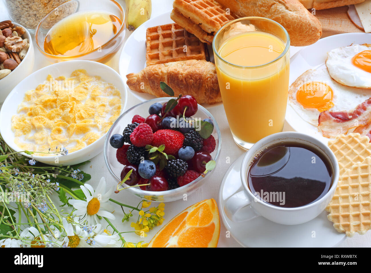 Healthy breakfast set with muesli, fruits, berries, nuts, coffee, eggs ...