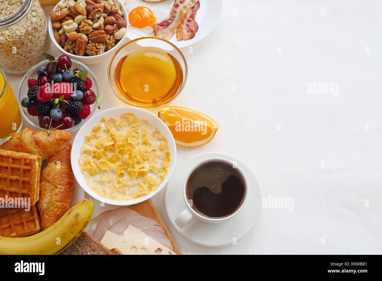 Healthy breakfast with muesli, fruits, berries, nuts, coffee, eggs ...