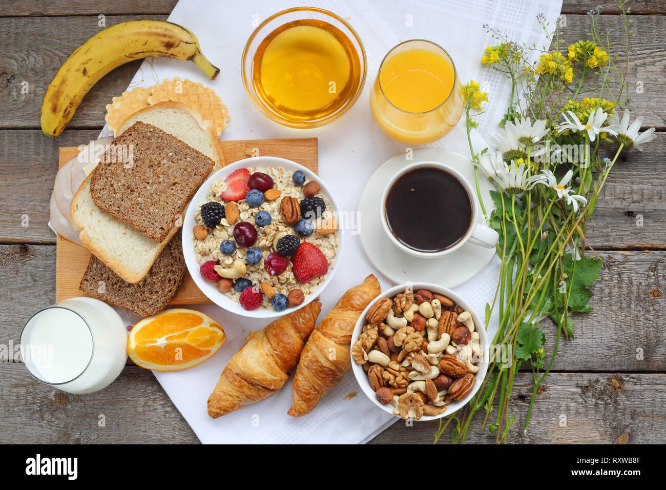 Healthy breakfast with muesli, fruits, berries, nuts, coffee, eggs ...