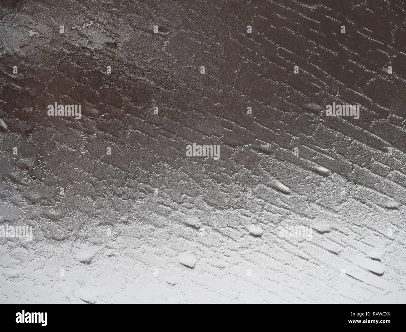 Close up of an icy, frost-covered window with a pattern of spikes and ...