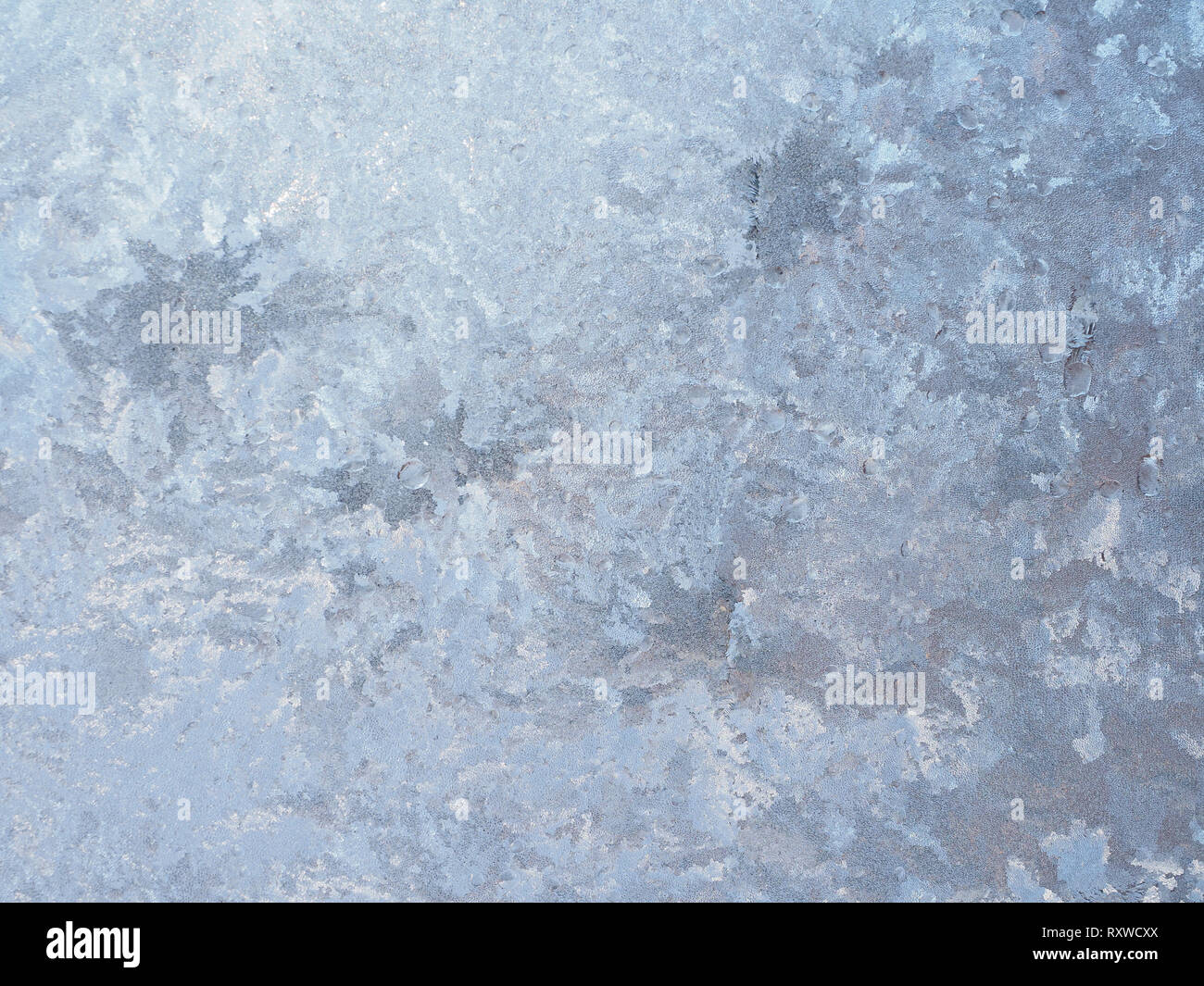 Small circular ice crystals with a light gray color on a frosty window ...
