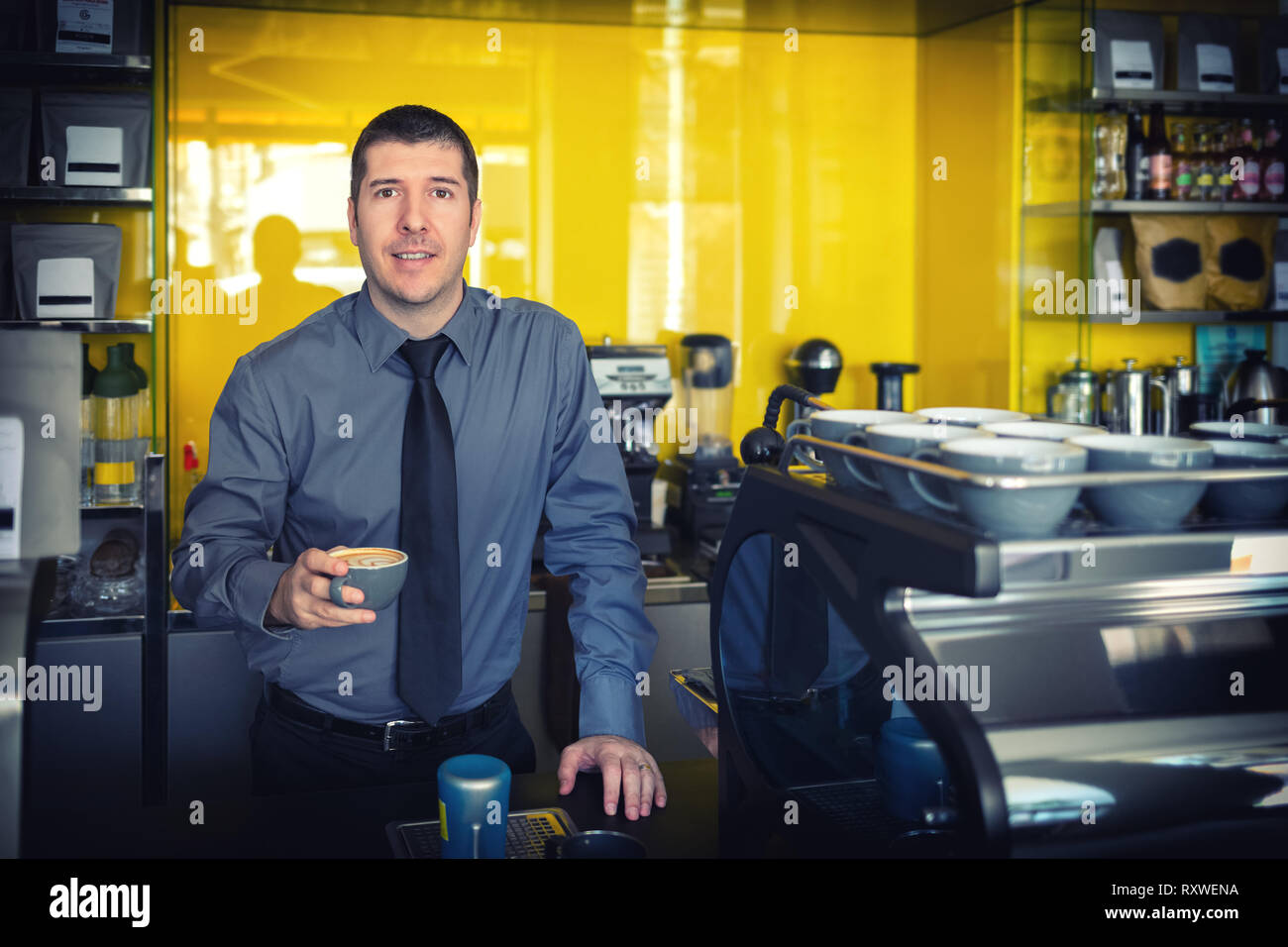 Portrait of small business owner smiling and standing behind counter ...