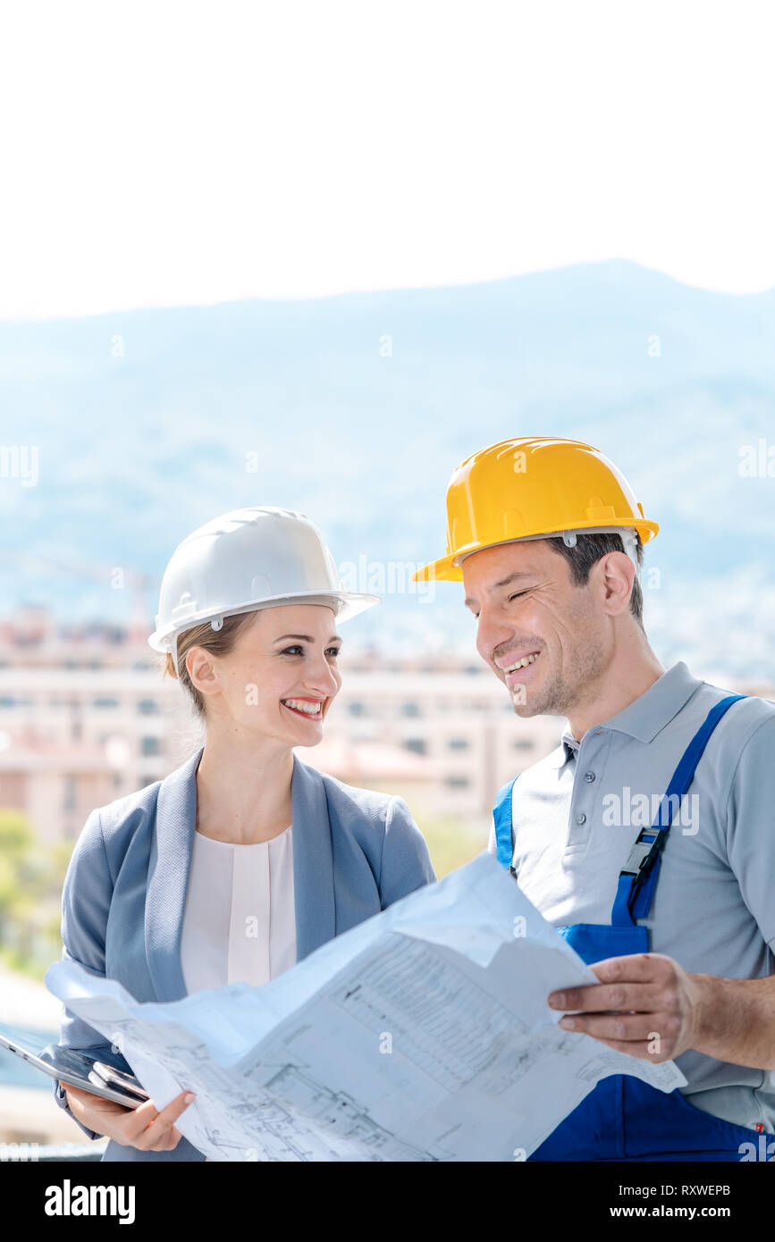 Principal and builder reading blueprints on construction site Stock Photo - Alamy