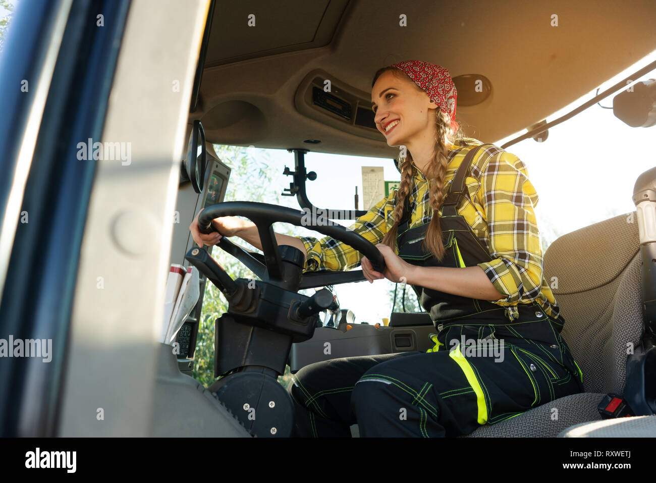 Farmer woman driving a tractor Stock Photo - Alamy