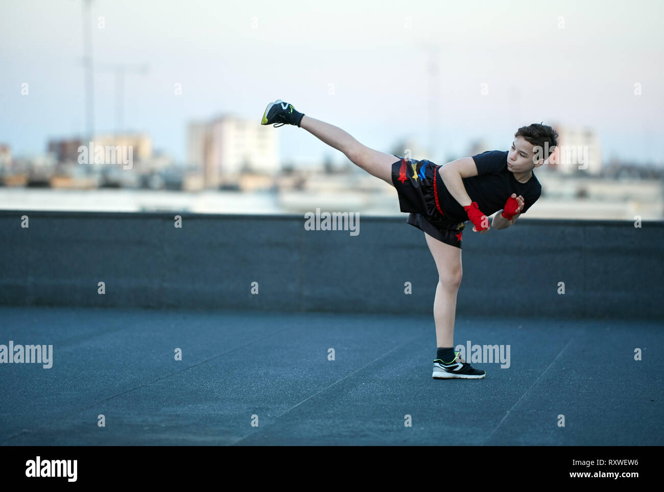 Boy fighter training on roof with buildings in blurred background Stock ...