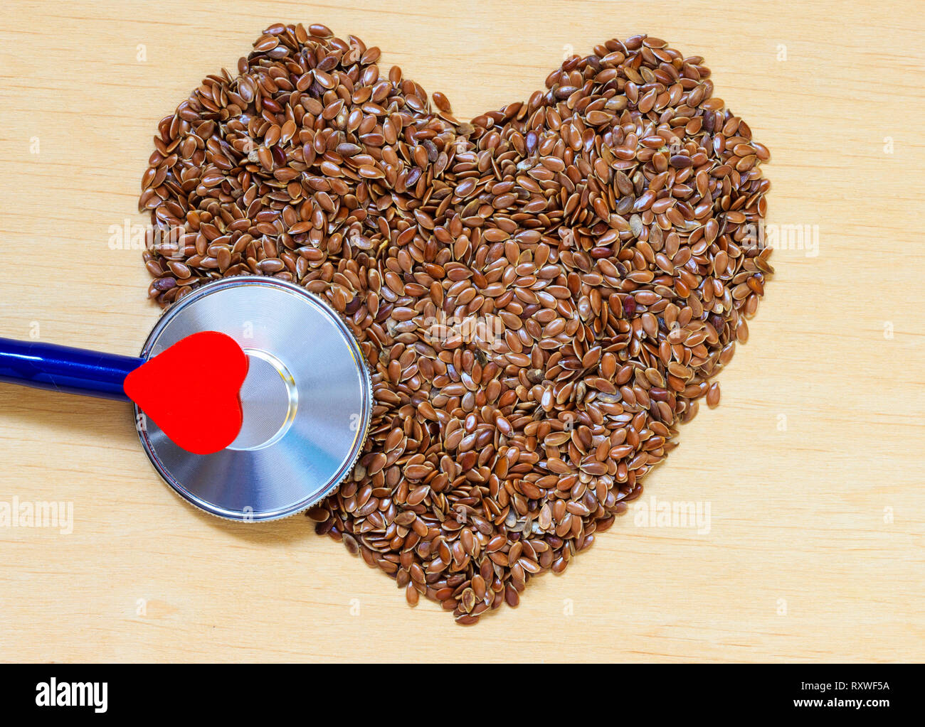 Diet healthcare and checkup concept. Raw flax seeds linseed heart shaped and stethoscope ...