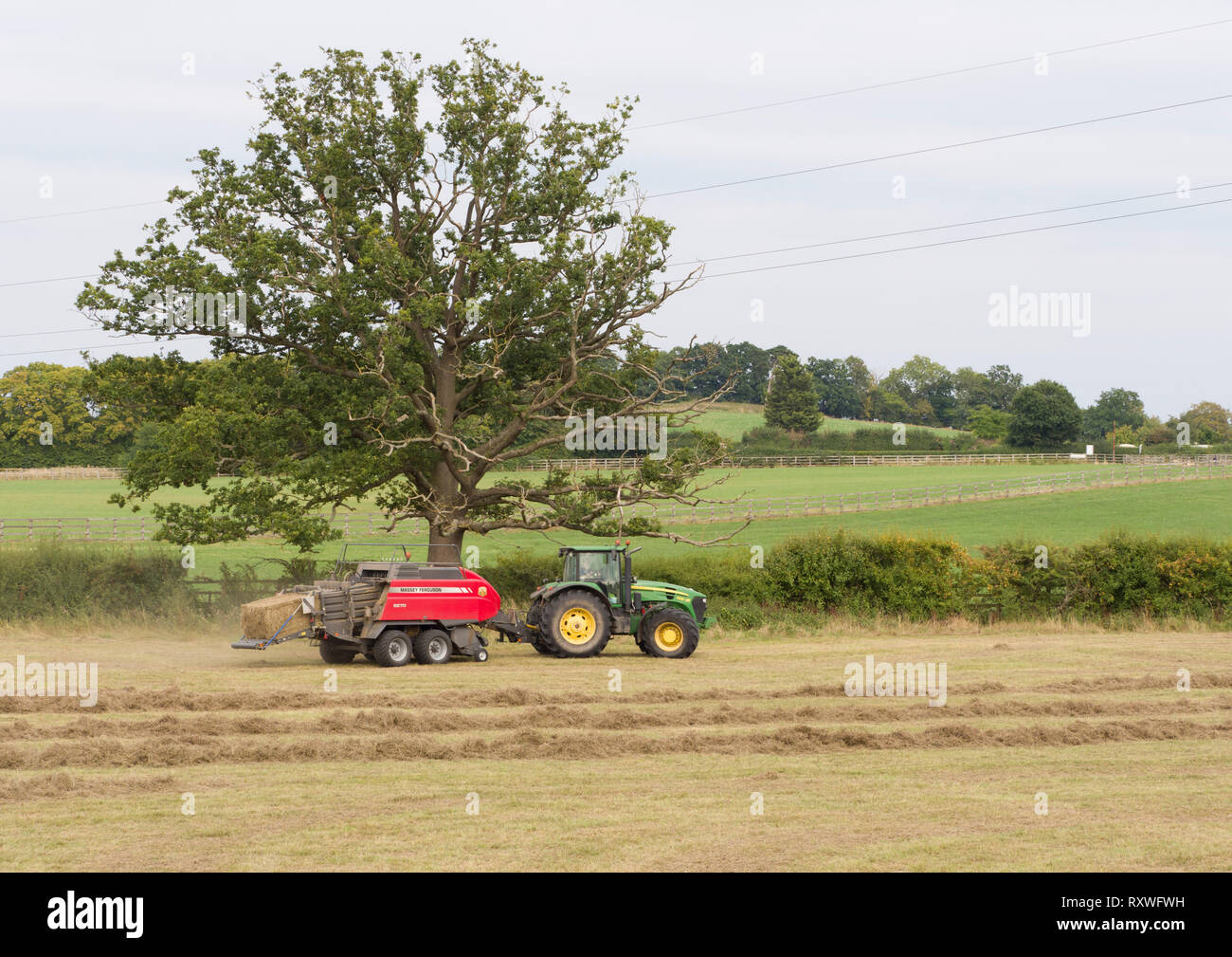Hay baler and tractor harvesting hay in field, Worcestershire, UK Stock ...