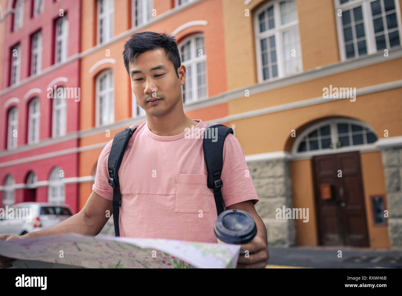 Young Asian man reading a map while exploring the city Stock Photo - Alamy