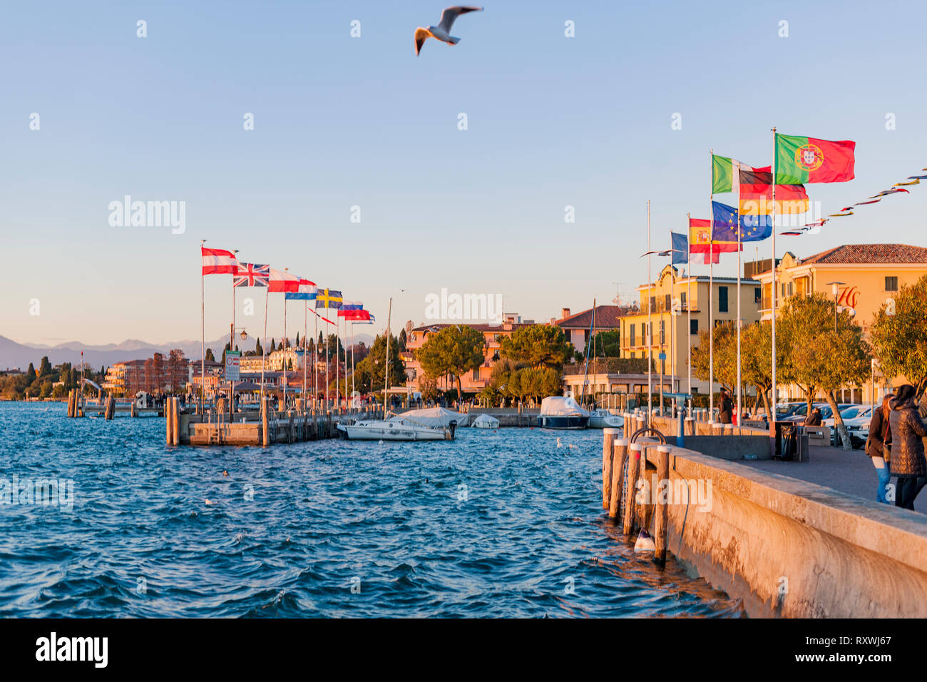 Sunset with red-yellow sun on a lake or sea. Sky, shore, sun and water ...